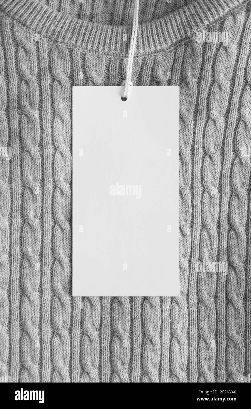 White clothing tag mockup on a grey sweater Stock Photo - Alamy