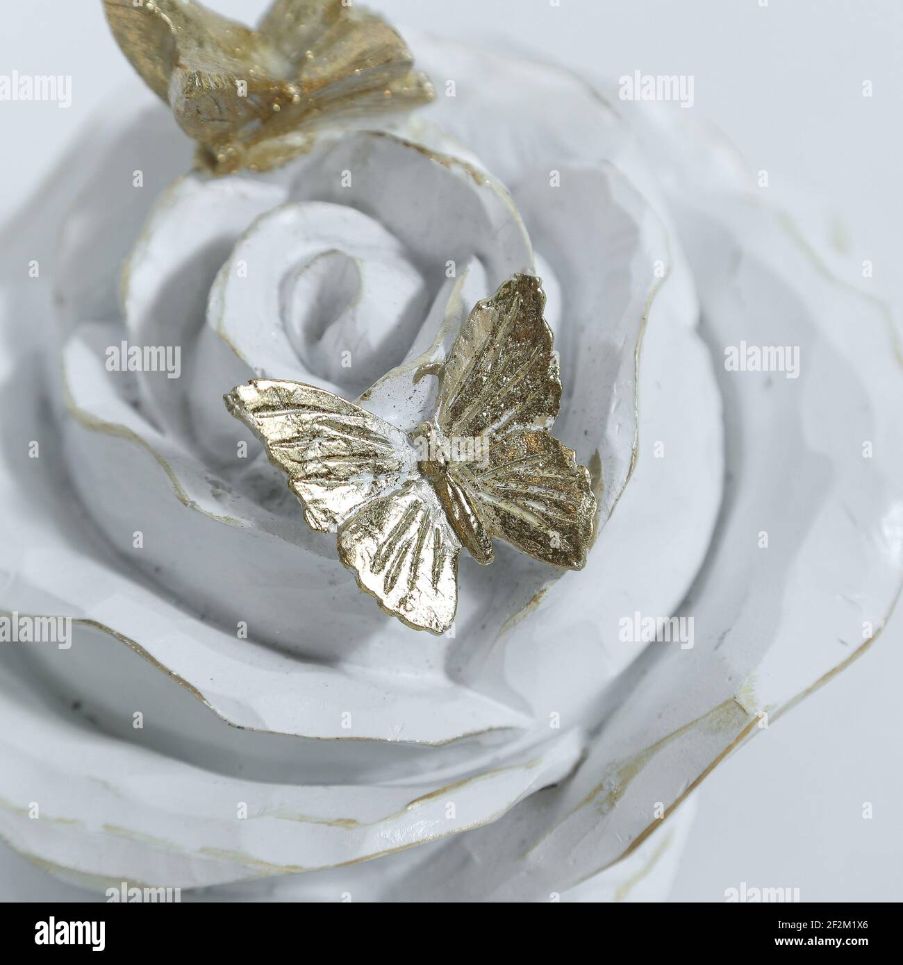 A closeup of rose and butterfly figures isolated on white background ...