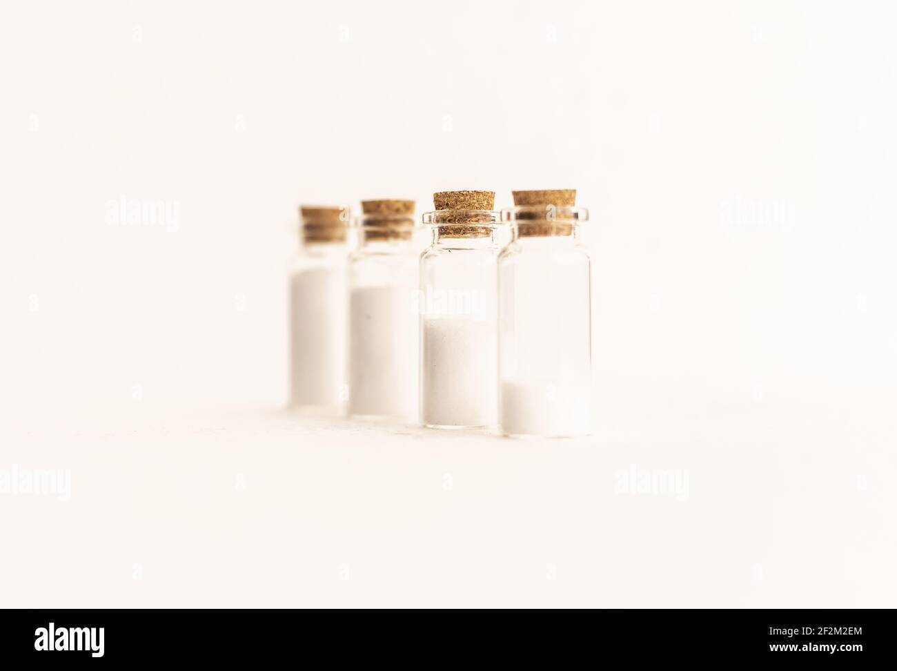 A closeup of small bottles with sea salt isolated on a white background ...