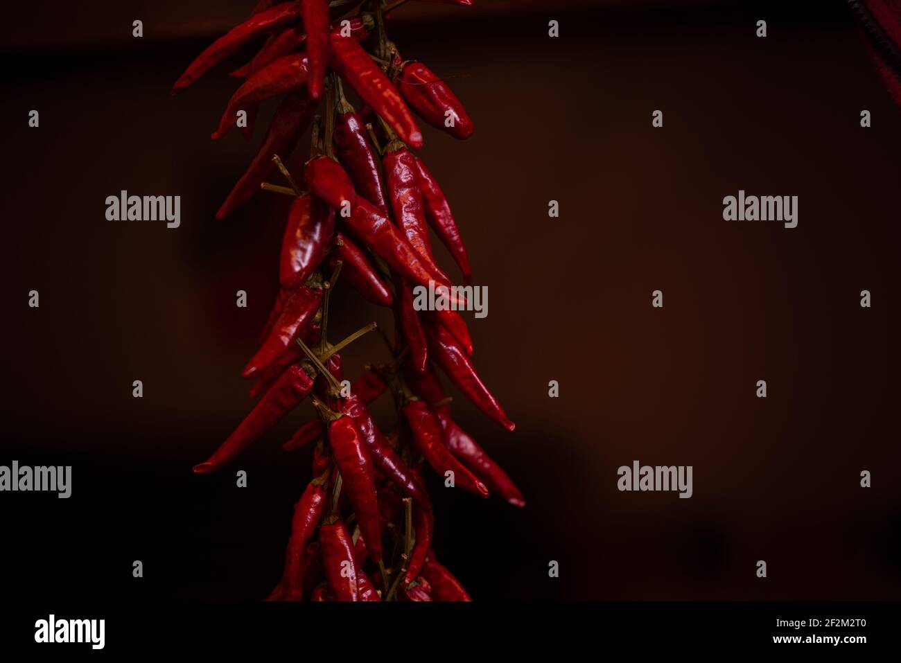 A closeup shot of dried red chili peppers on a string Stock Photo - Alamy