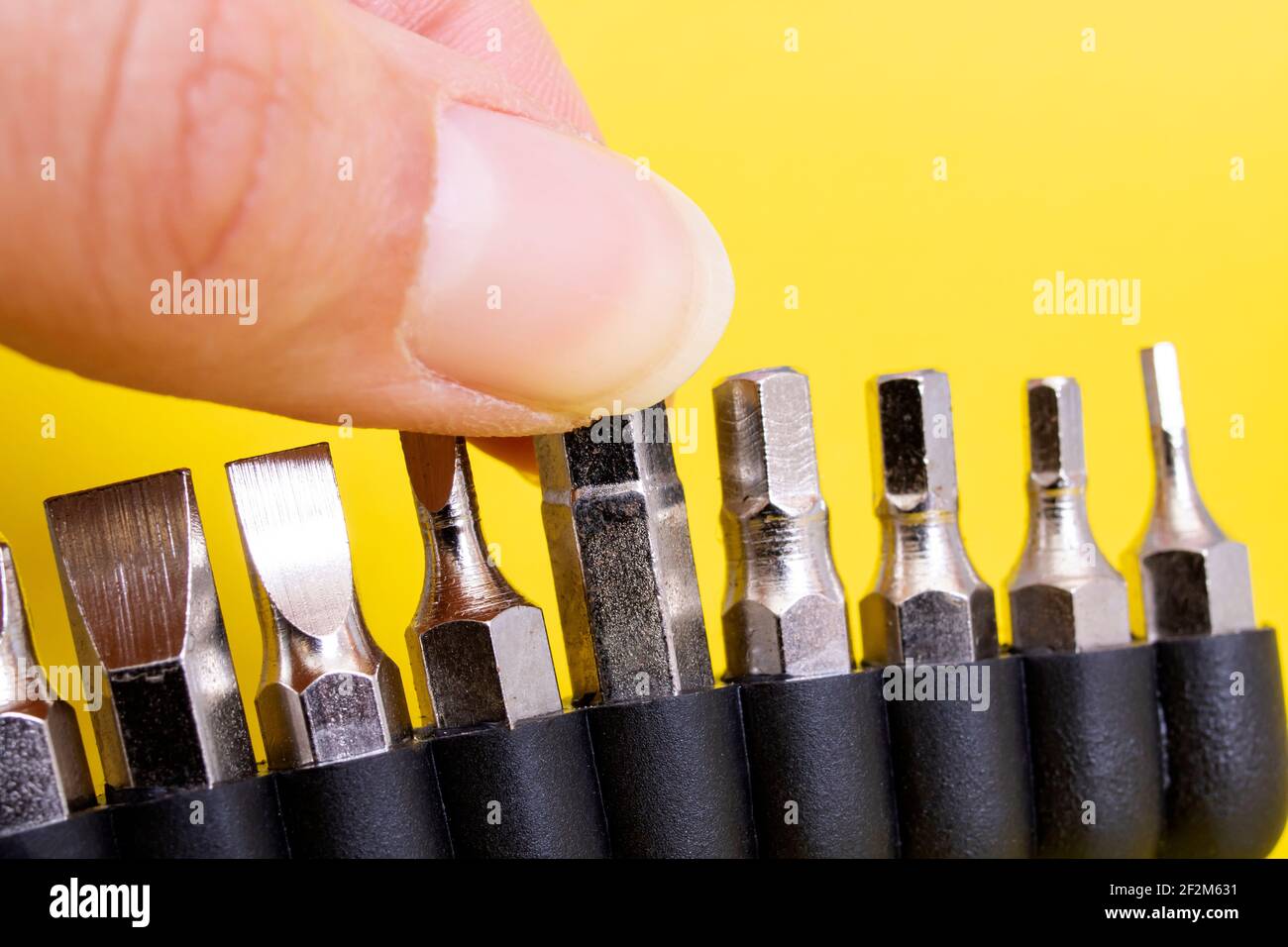 Screwdriver bits in a row on yellow background close up Stock Photo - Alamy