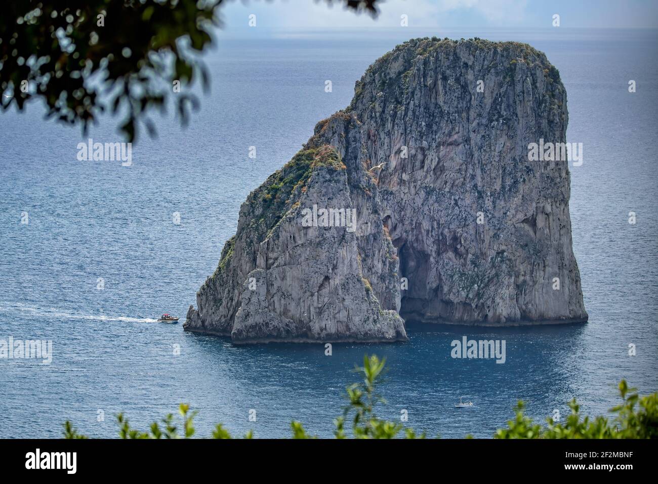 Excursion boat at the Faraglioni Rocks. View of the famous Faraglioni ...