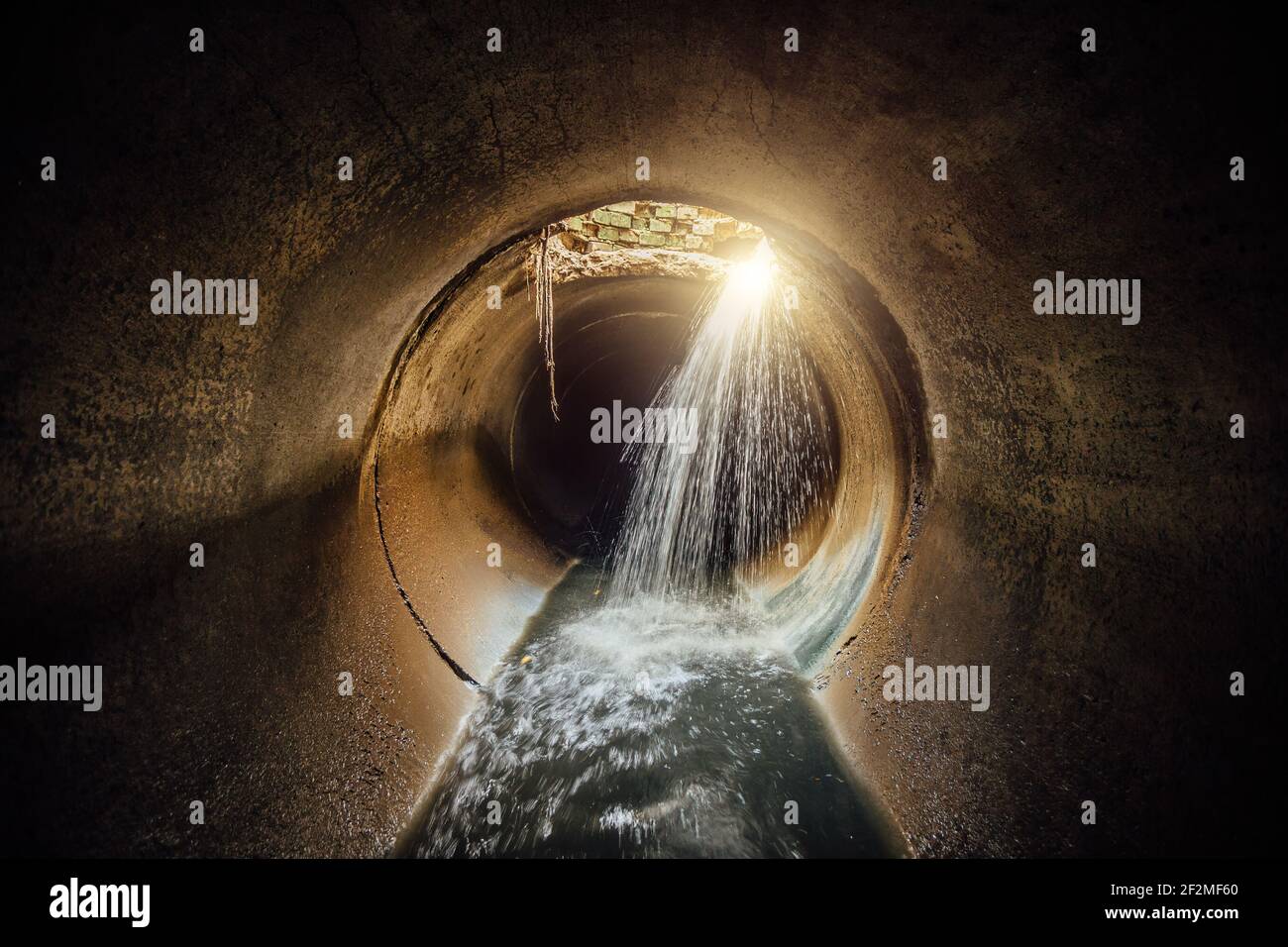 Flooded round sewer tunnel with water reflection Stock Photo - Alamy
