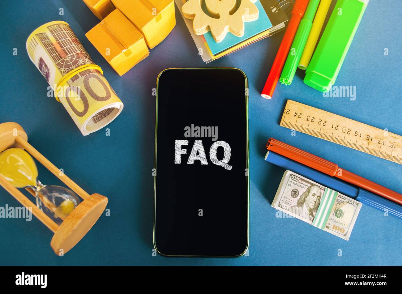 Mobile phone with the inscription FAQ (frequently asked questions ...