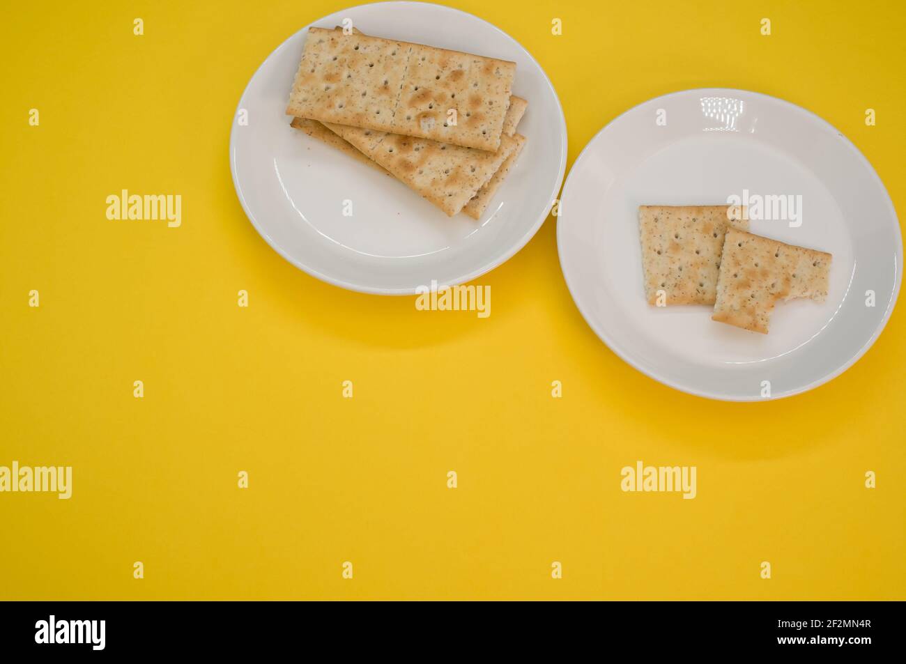 The two plates with salty crackers on a yellow surface Stock Photo - Alamy