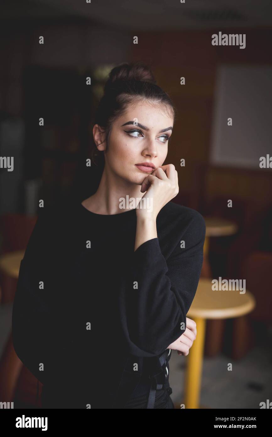 A shallow focus of a young brunette Caucasian female with simple makeup ...