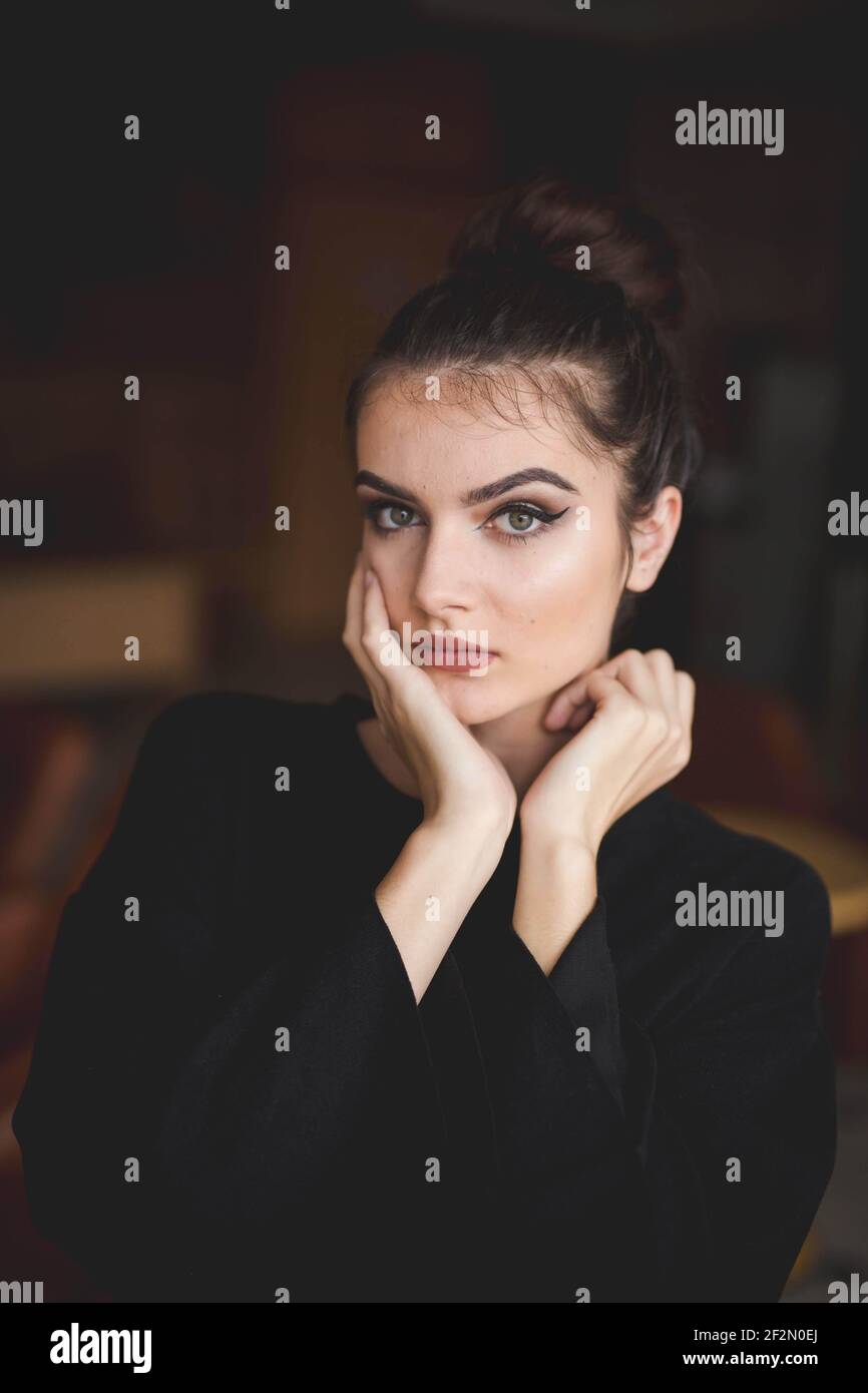 A shallow focus of a young brunette Caucasian female with simple makeup ...