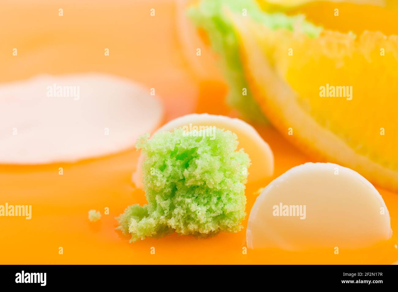 Kiwi siphon sponge on orange glazed cake. Macro. Photo can be used as a ...
