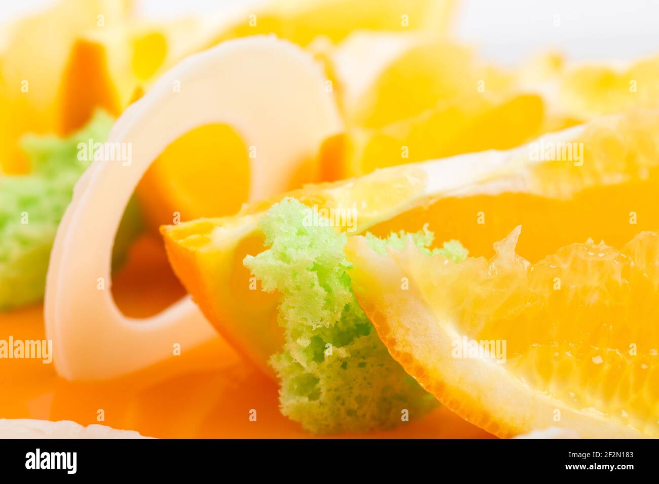 Kiwi siphon sponge on orange glazed cake. Macro. Photo can be used as a ...