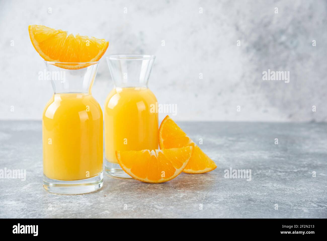 Glass pitchers of juice with slice of orange fruit Stock Photo - Alamy