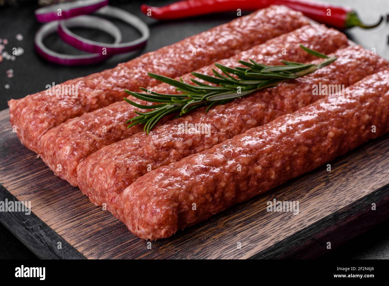 Fresh raw mince for grilled kebab with spices and herbs on a dark ...