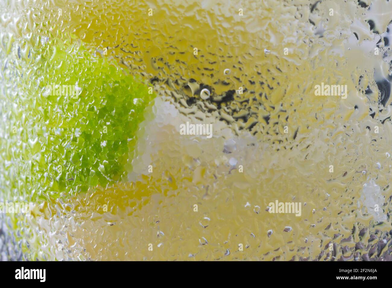 a slice of lime fruit in a fizzy sparkling water, on a black background ...