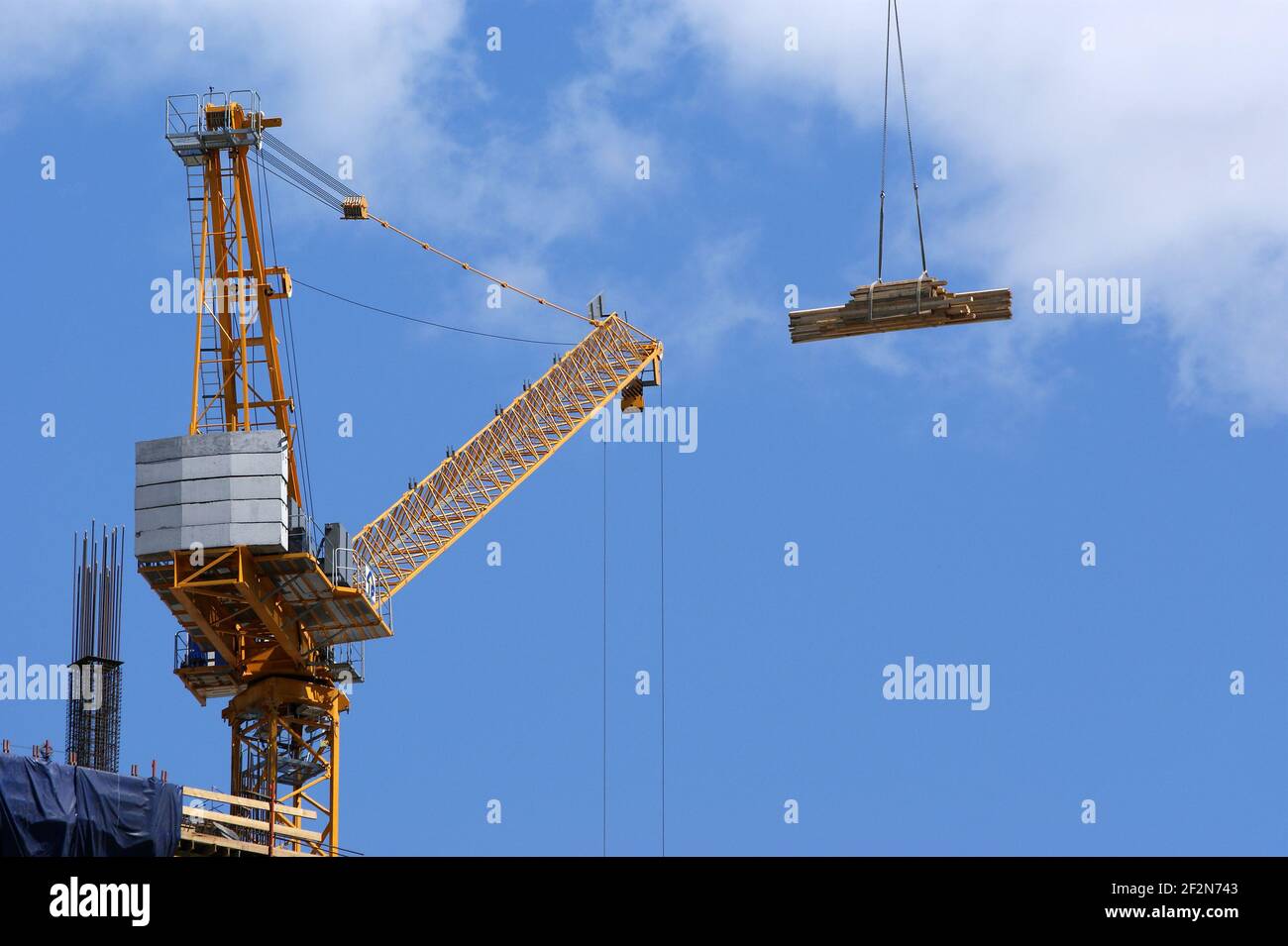 Construction crane at the windows of a skyscraper backdrop of glass and ...
