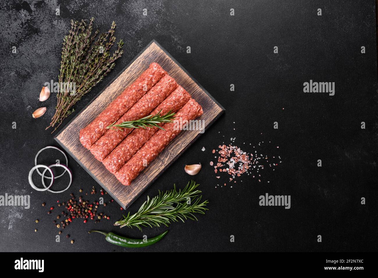 Fresh raw mince for grilled kebab with spices and herbs on a dark ...