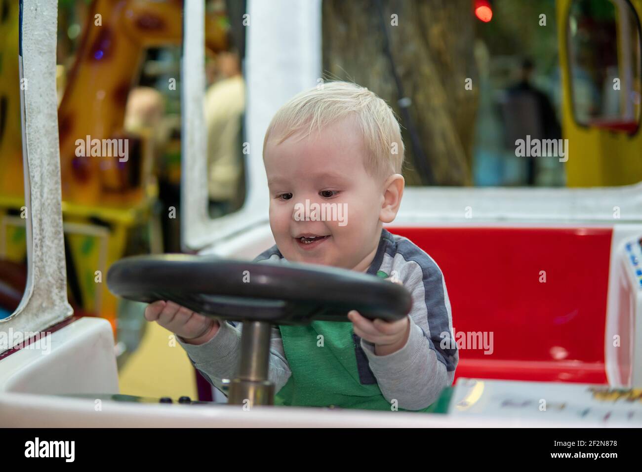 Funny little smiling kid boy driving toy car Stock Photo - Alamy