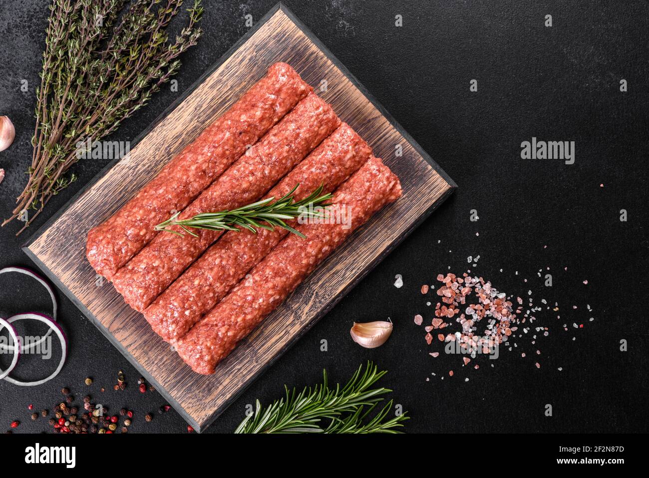 Fresh raw mince for grilled kebab with spices and herbs on a dark ...