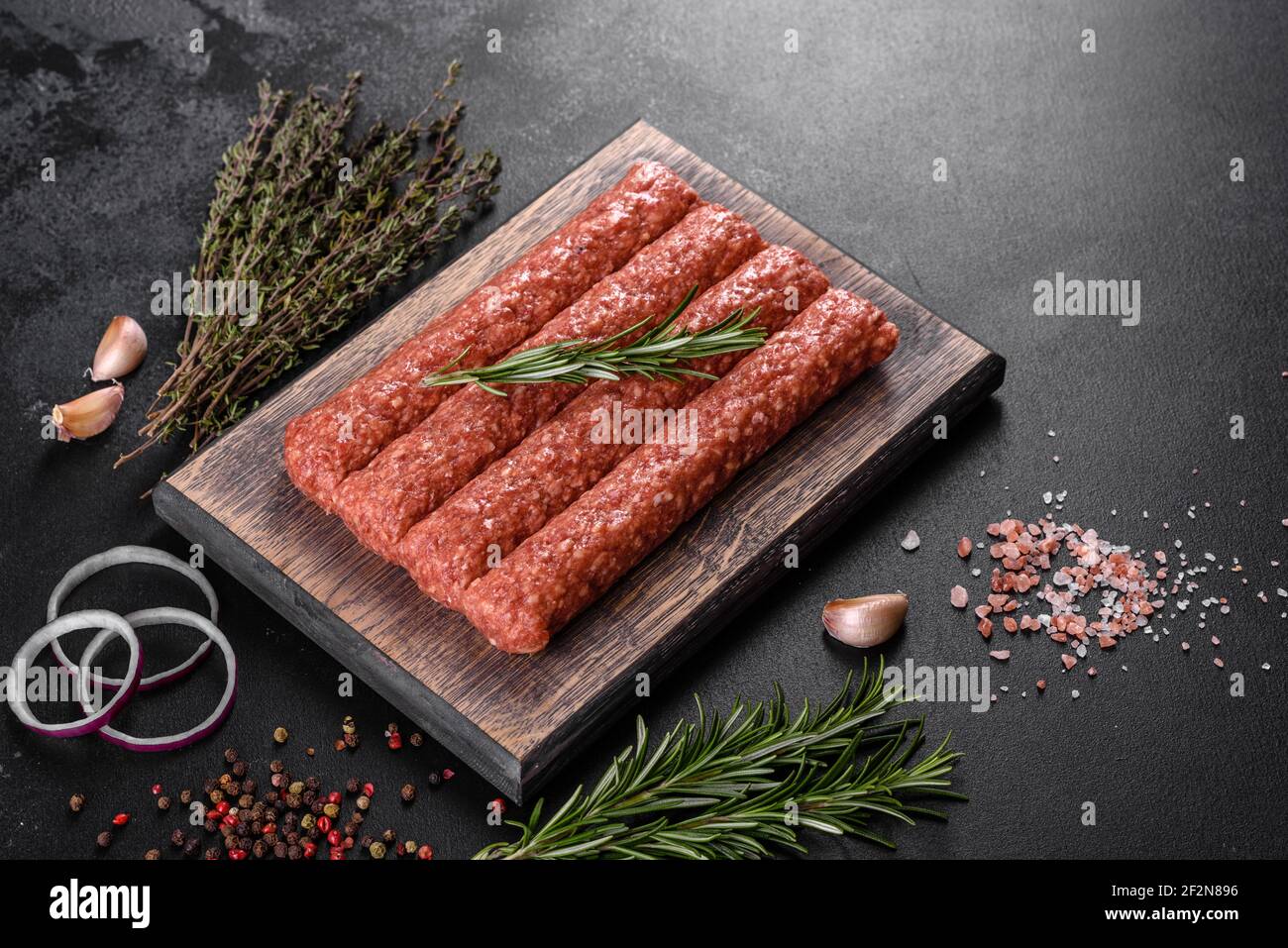 Fresh raw mince for grilled kebab with spices and herbs on a dark ...