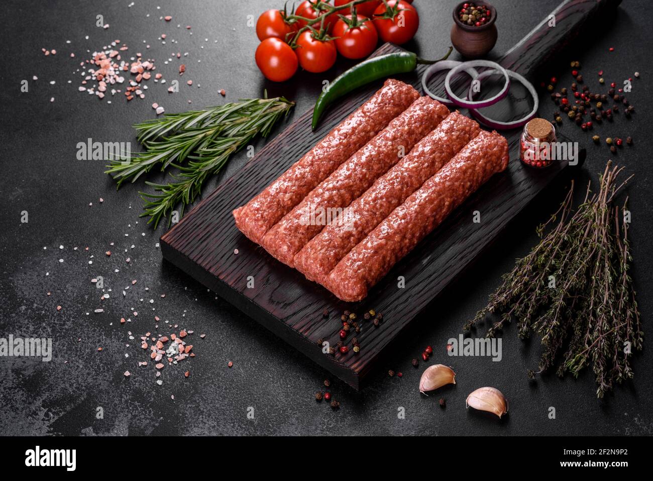 Fresh raw mince for grilled kebab with spices and herbs on a dark ...