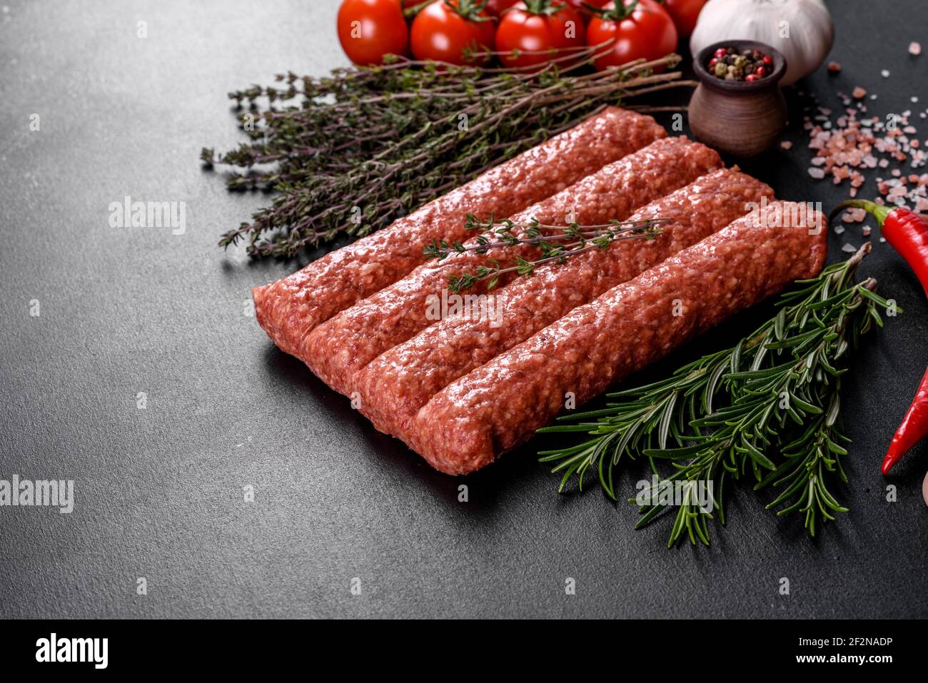 Fresh raw mince for grilled kebab with spices and herbs on a dark ...