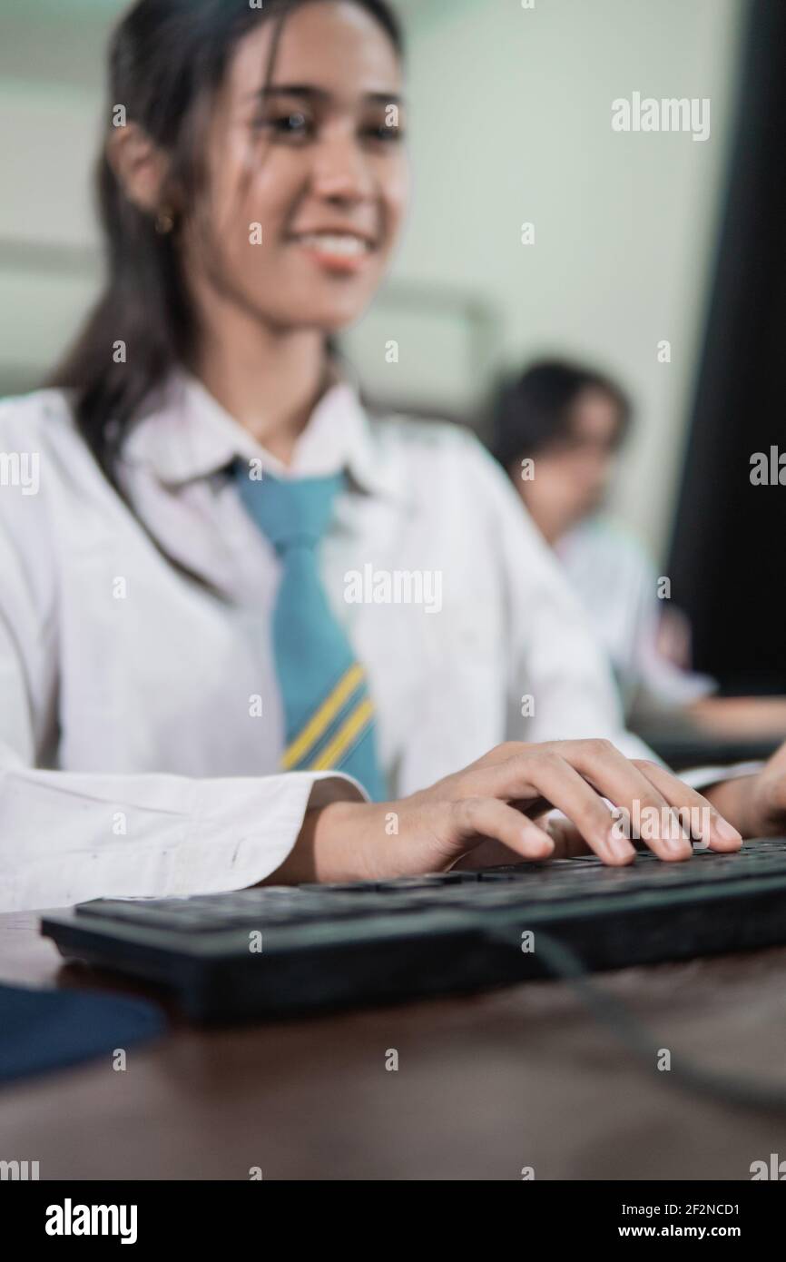 Close up of female students' hands typing on the keyboard while using ...