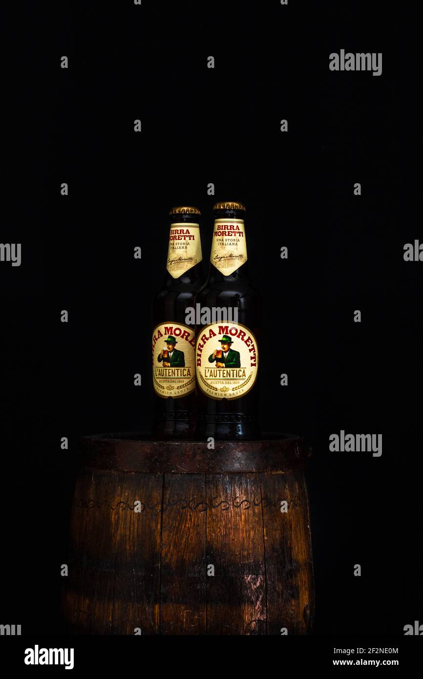 Bottle of Birra Moretti beer on wooden barrel with dark background ...