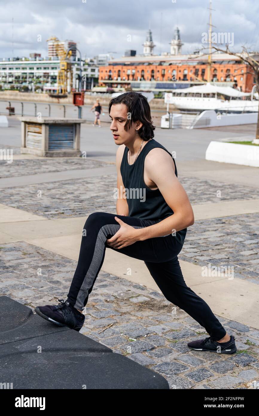 Young latino man doing muscle stretching before exercise Stock Photo ...