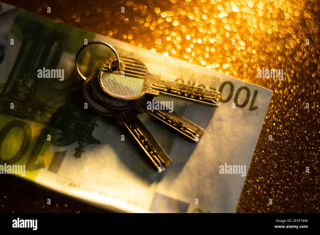 keys and money banknotes on golden background Stock Photo - Alamy