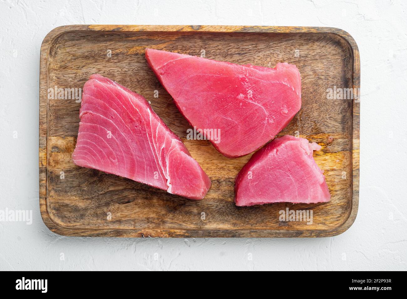 Raw organic tuna fillet. Seafood set, on wooden tray, on white stone ...