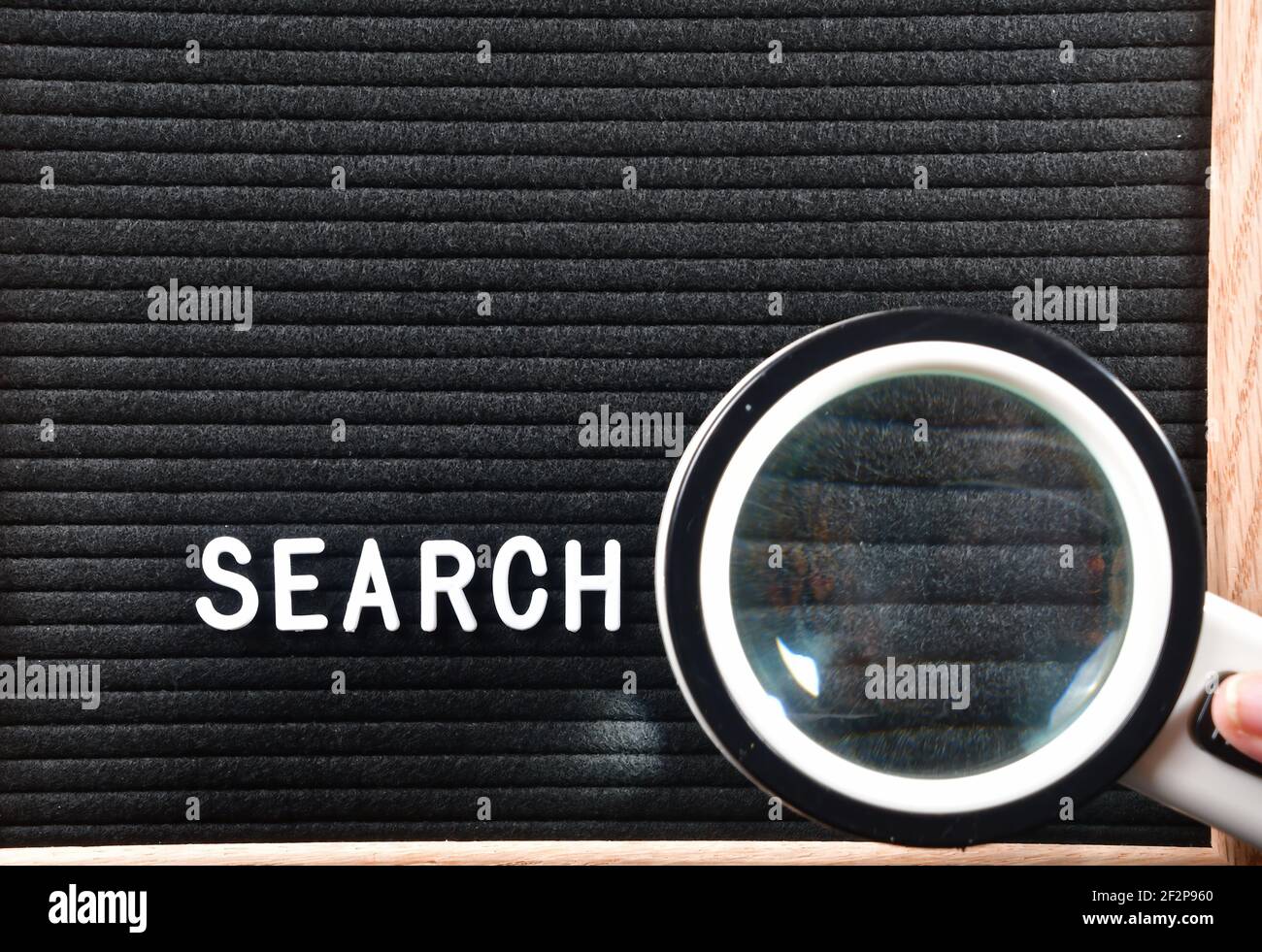 A magnifying glass and the word SEARCH on a black letterboard Stock ...