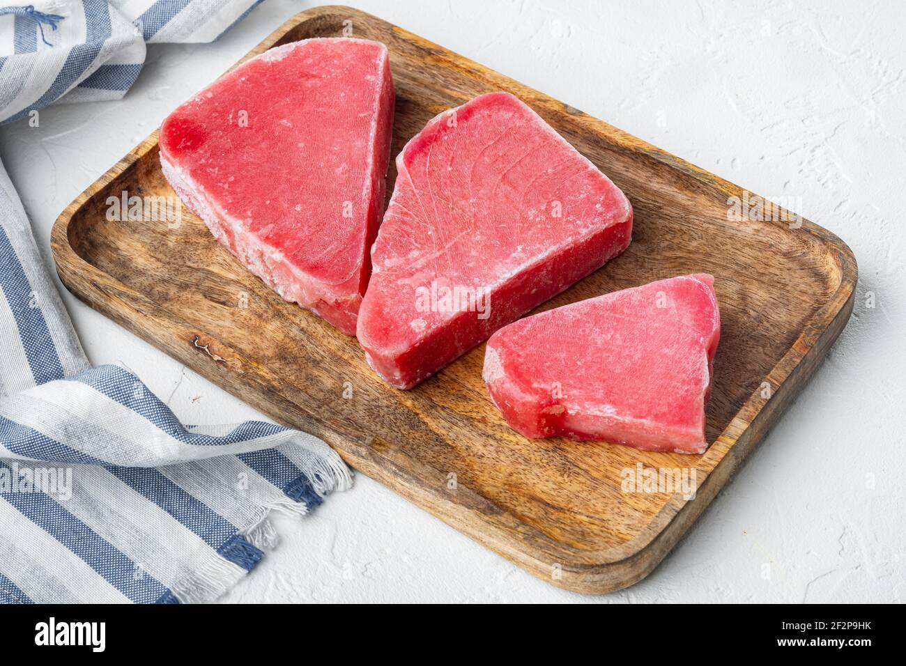 Raw frozen tuna fish fillet set, on wooden tray, on white stone ...