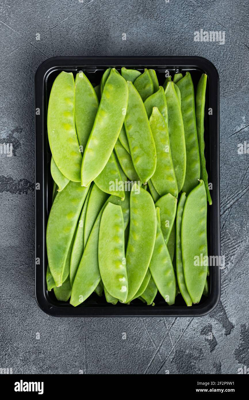 Sugar snap peas, raw ripe baby pods set, in plastic container, on gray ...