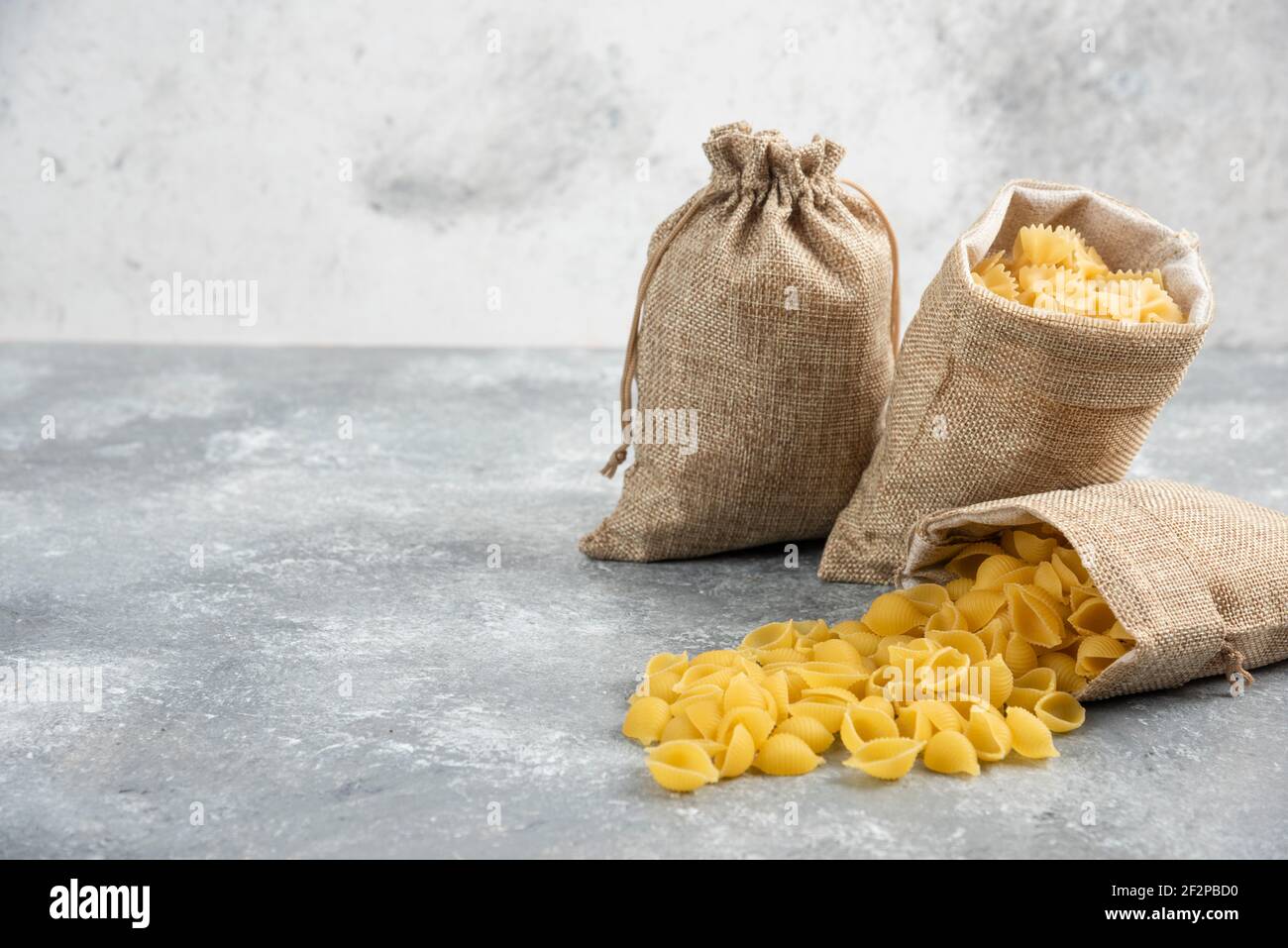 Spiral pasta in a paper bag on a white background. Copy, empty space ...