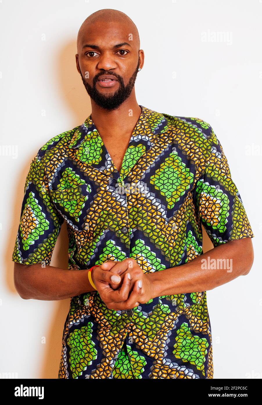 portrait of young handsome african man wearing bright green national ...