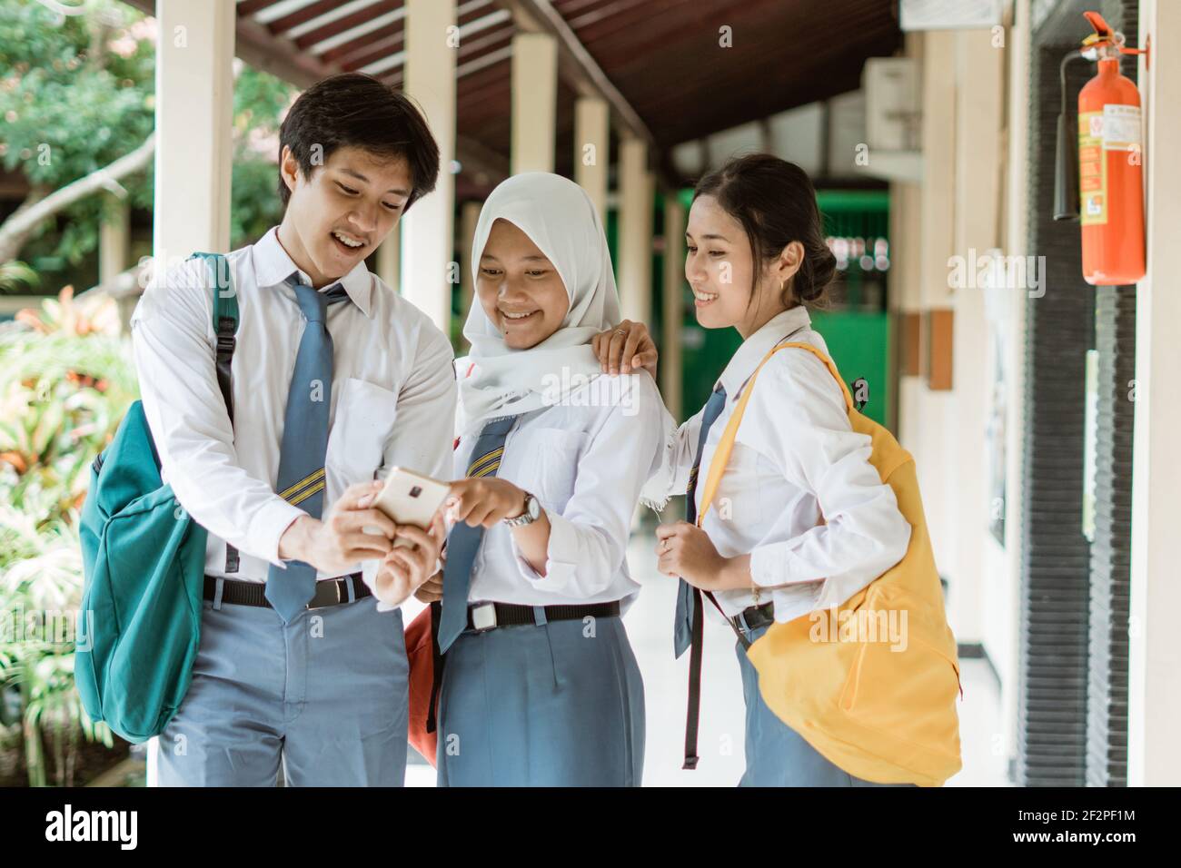 a boy and friends high school students look together with point to the ...
