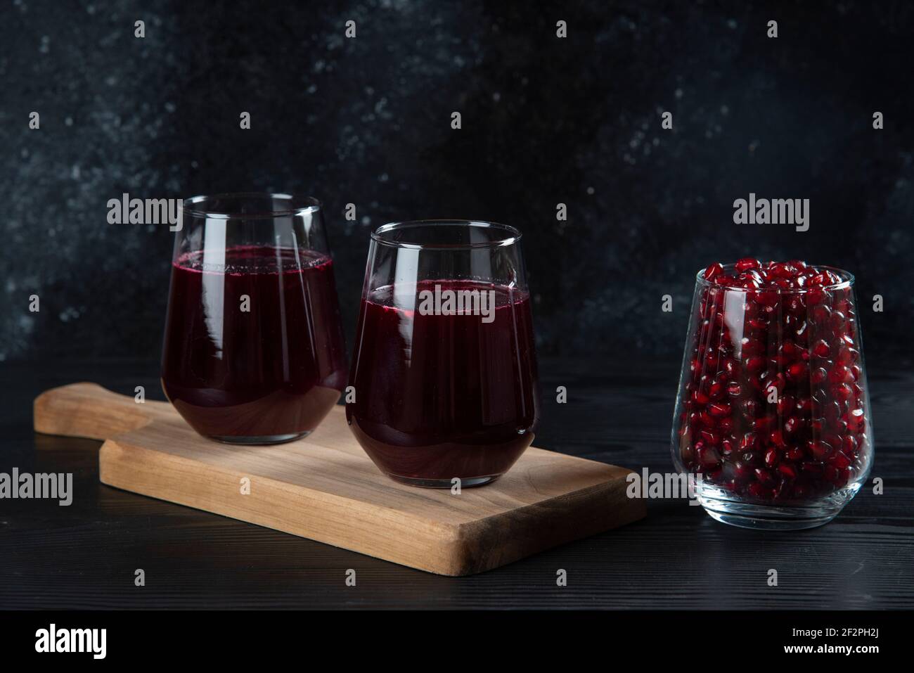 Two glass cups of fresh pomegranate juice on a wooden board Stock Photo ...