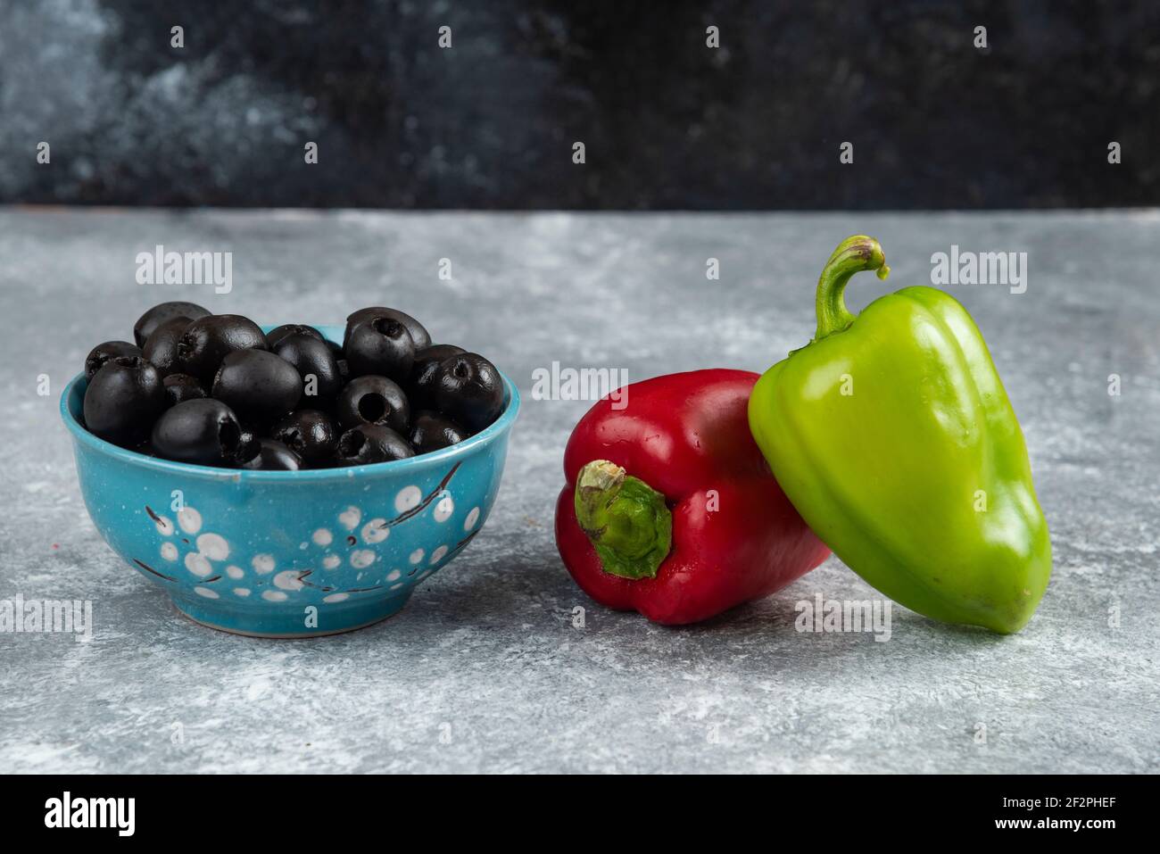 Black olives and bell peppers on marble background Stock Photo - Alamy