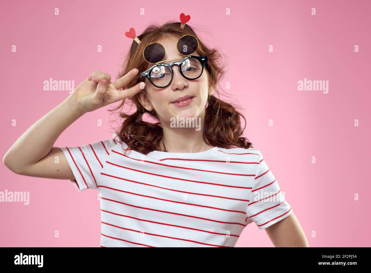 Fashionable girl with clothespins in the form of hearts on her head and ...