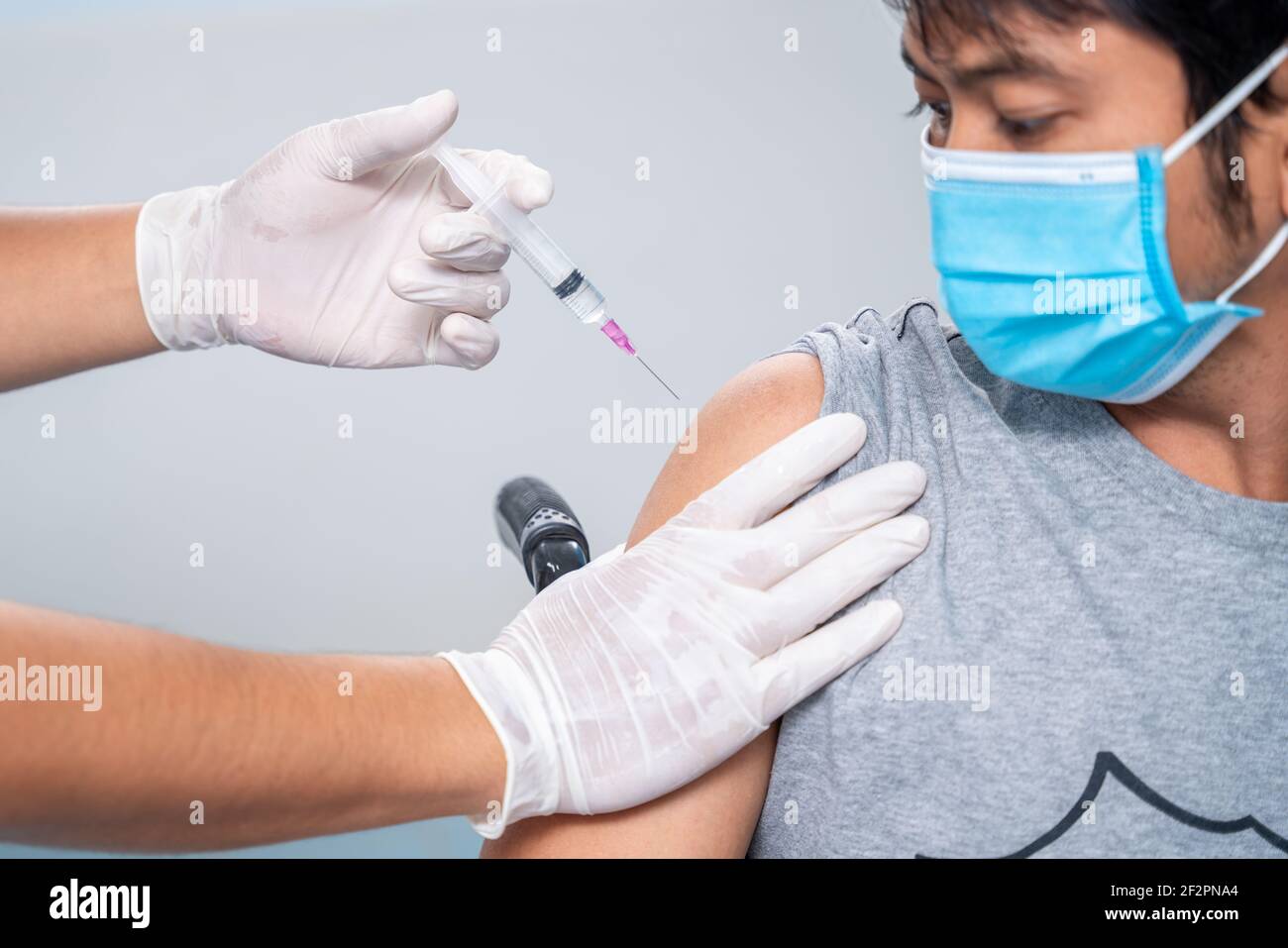 Doctor making a vaccination in the shoulder of patient Disabled person ...