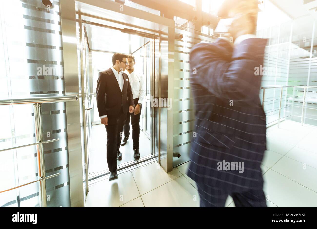 Business team group going on elevator. Business people in a large glass ...