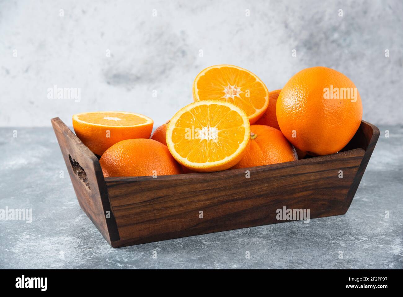 A wooden old box full of sliced and whole juicy orange fruits Stock ...