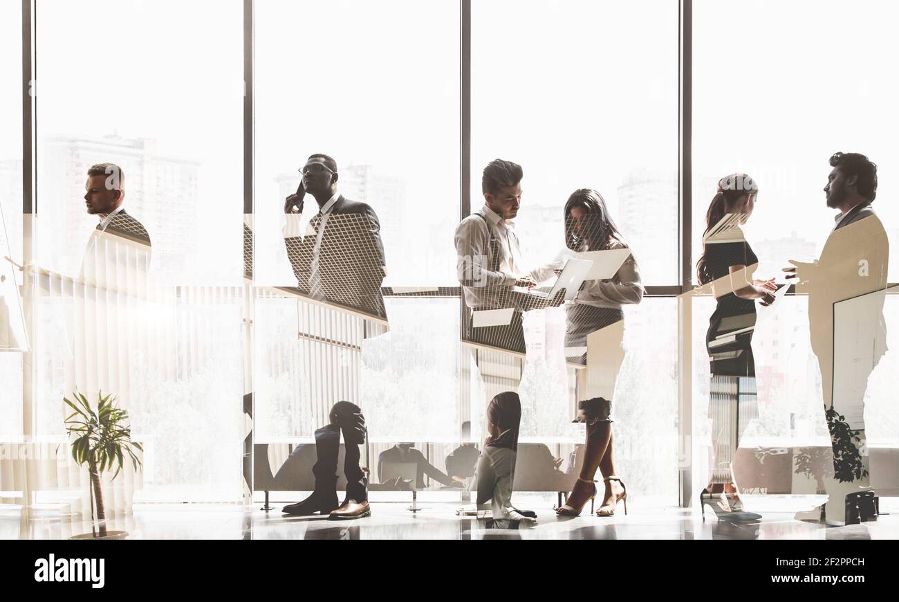 Silhouettes of people against the window. A team of young businessman ...