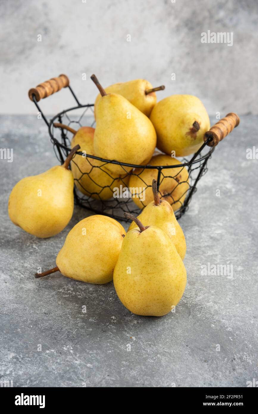 Bunch of fresh yellow pears in metal bucket on marble surface Stock ...