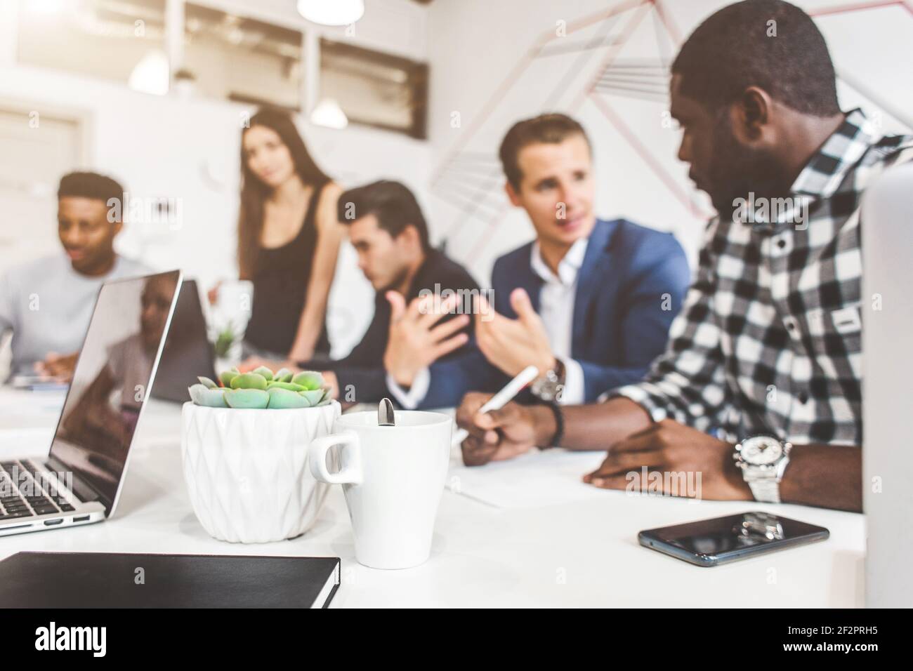A team of young office workers, businessmen with laptop working at the ...