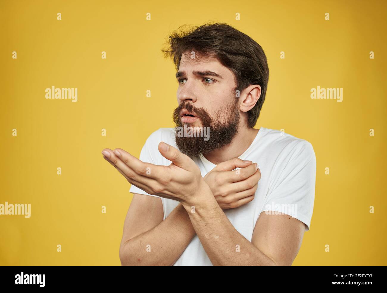 The man has his arms crossed over his chest against a yellow background ...