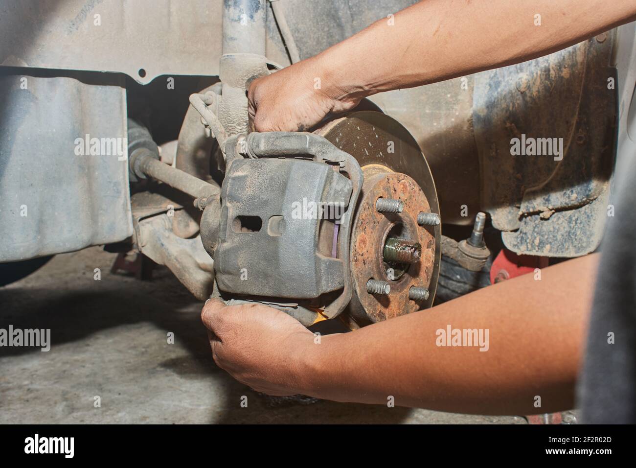 Car Mechanic Assemble Brake Caliper to Front Car Wheel Hub in Car ...