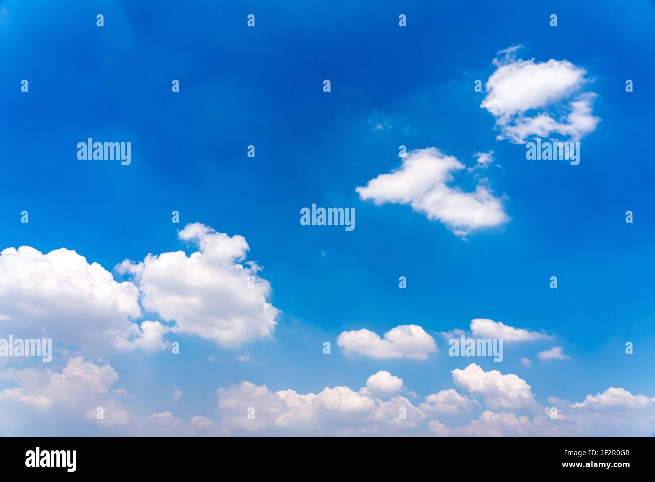 Typical cumulus white clouds on clear blue sky Stock Photo - Alamy