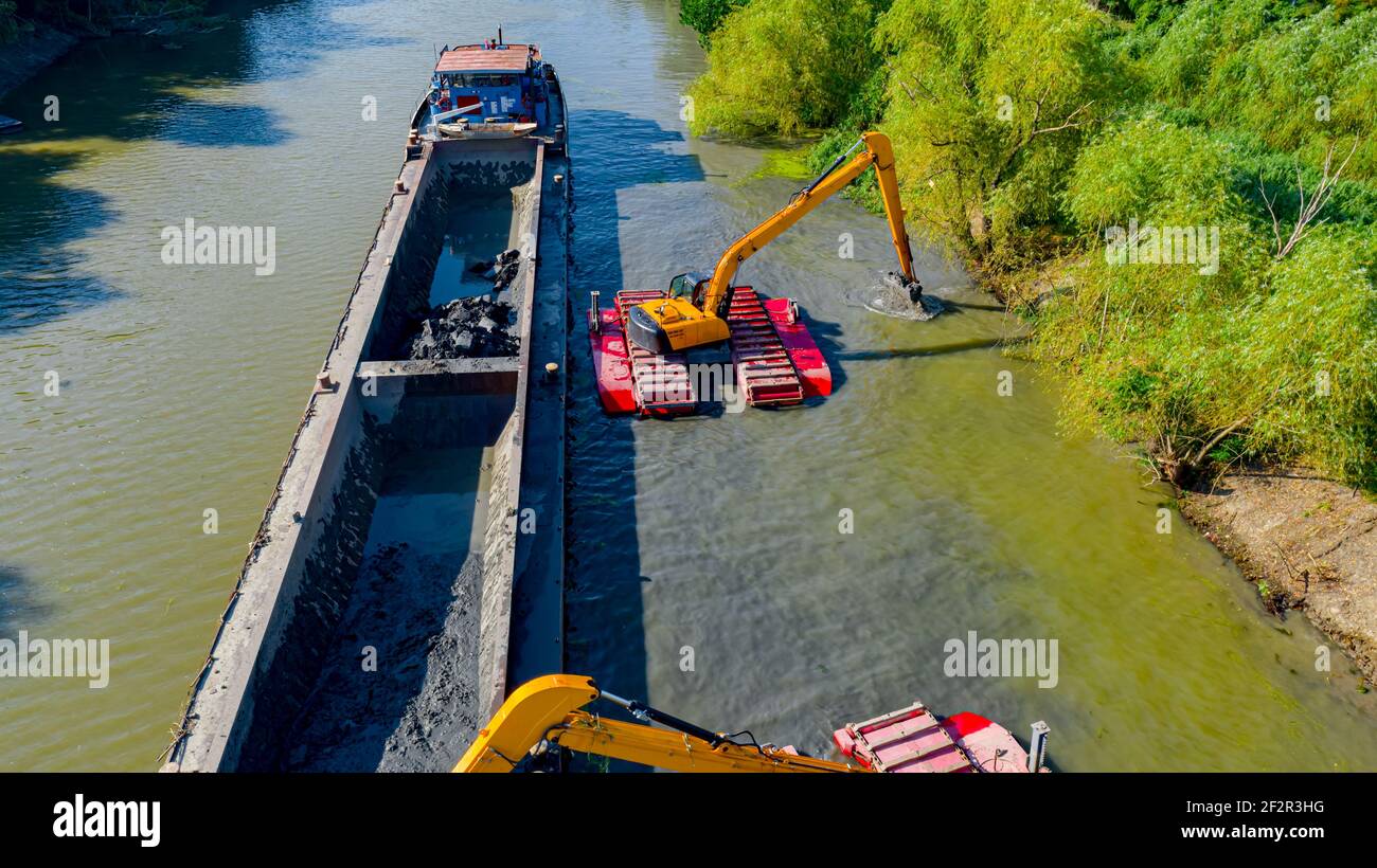 Above view on two excavators dredge as they dredging, working on river ...