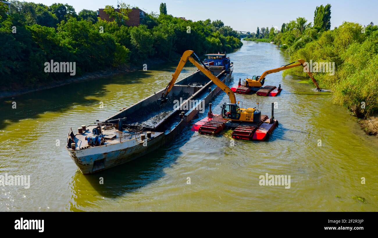 Above view on two excavators dredge as they dredging, working on river ...