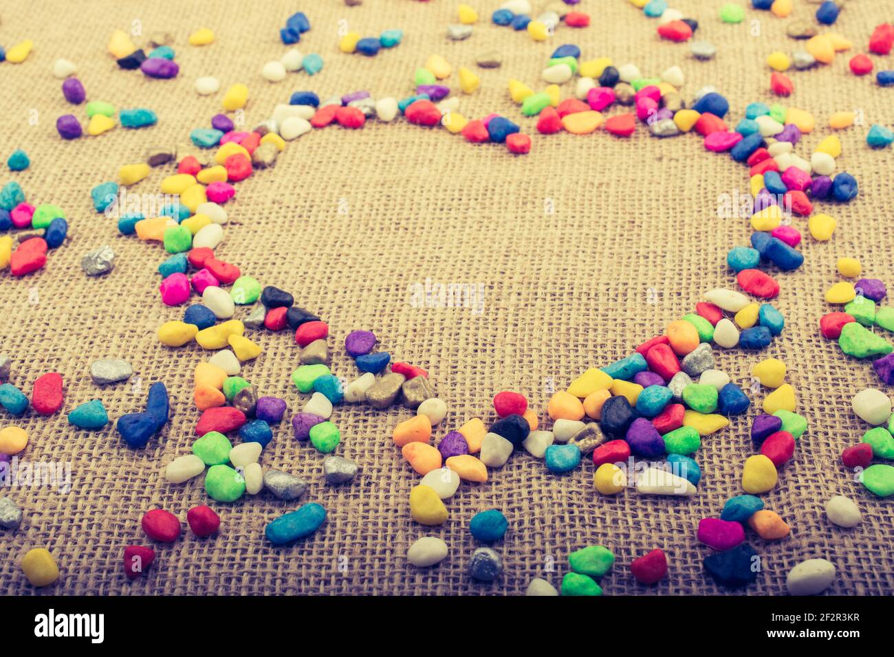 Colorful little pebbles form a heart shape on canvas ground Stock Photo ...