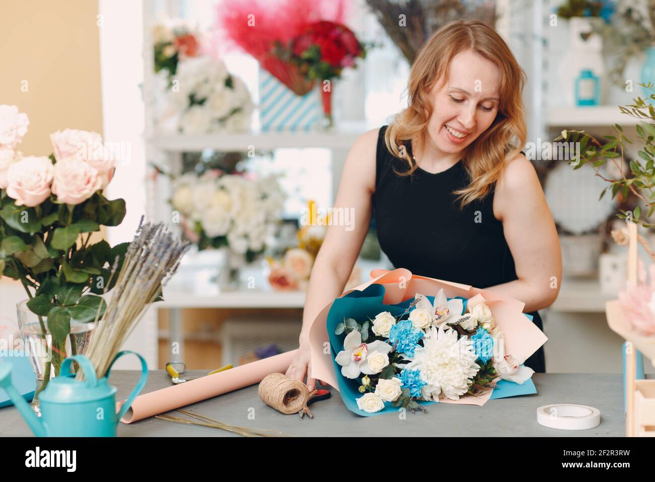 Florist woman make bouquet in flower boutique Stock Photo - Alamy